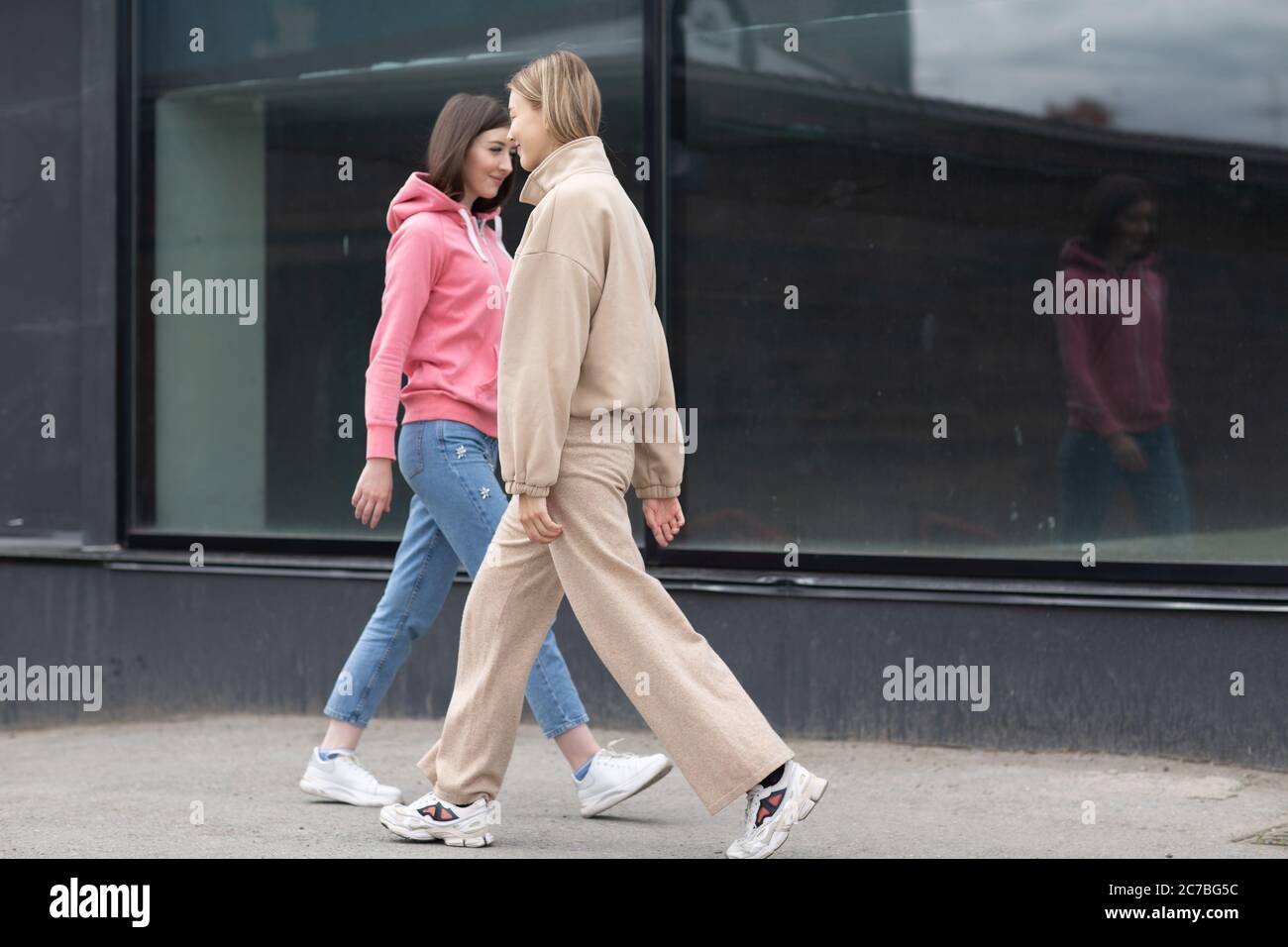 Two girls walking together hi-res stock photography and images - Alamy