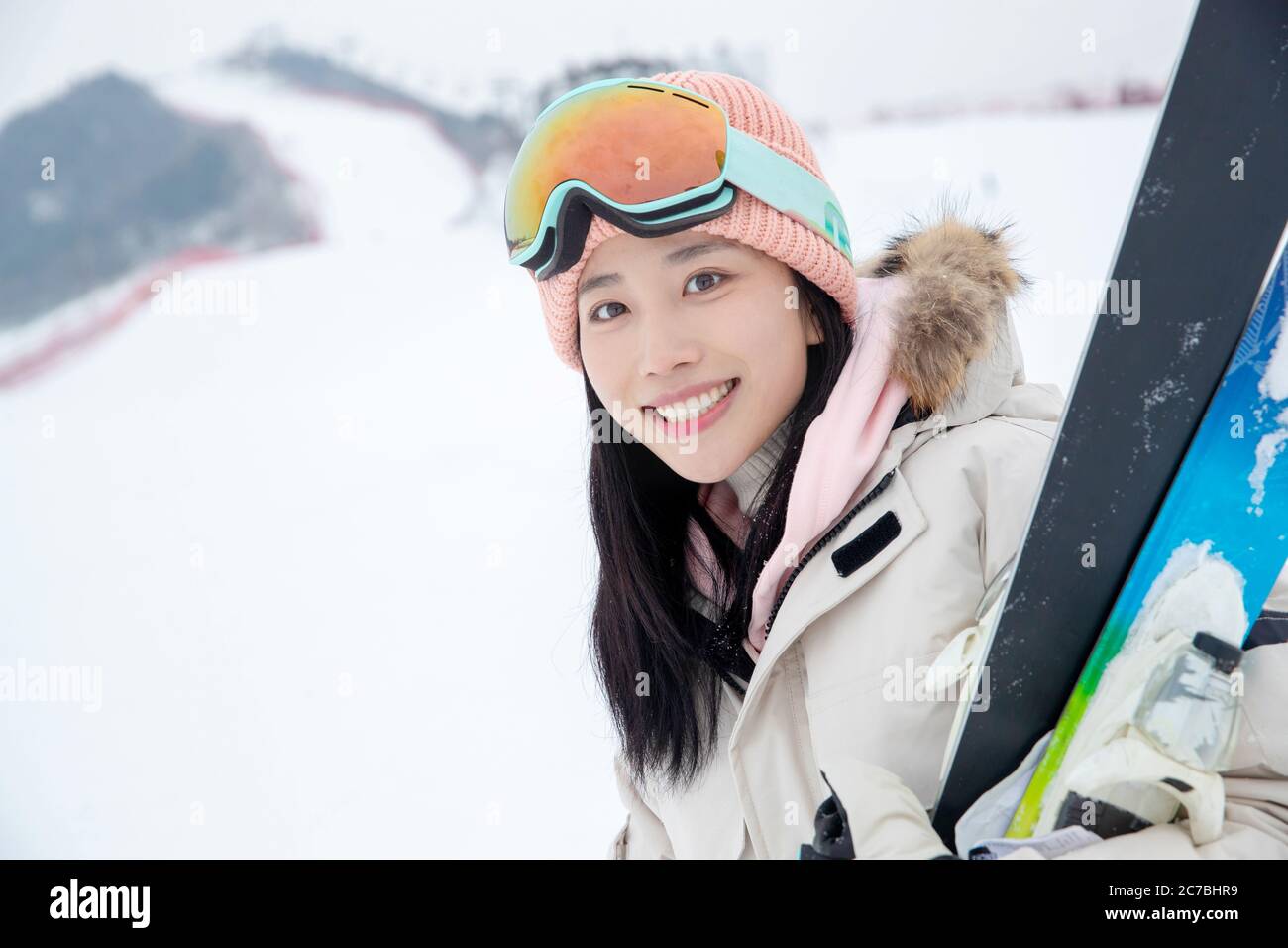 Skiing field holding the skis beautiful young woman Stock Photo - Alamy