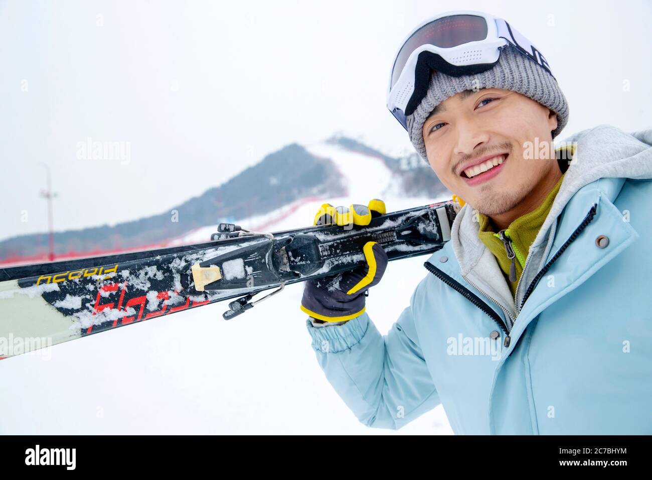 Young man holding skis hi-res stock photography and images - Alamy