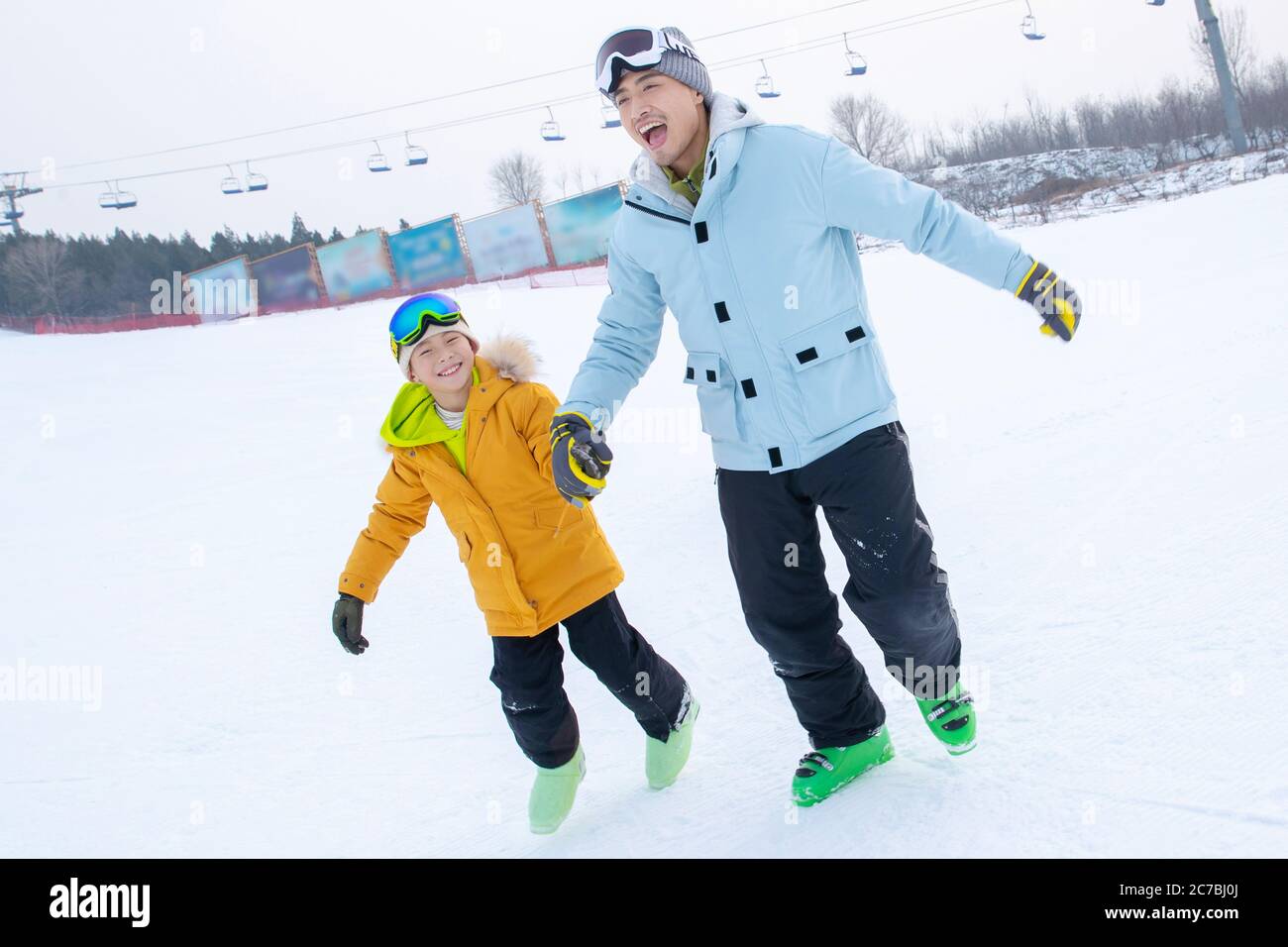 Happy father and son skiing field hand in hand Stock Photo - Alamy