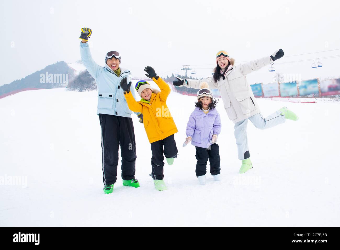 Skiing field cheering family of four Stock Photo - Alamy