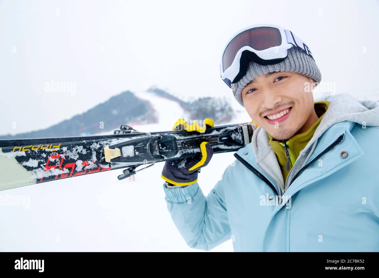 Young man holding skis hi-res stock photography and images - Alamy