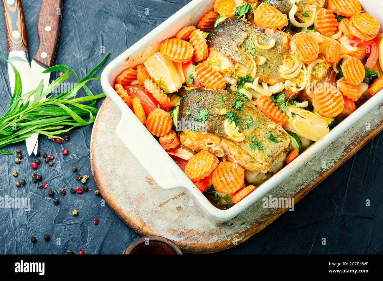 Baked fish steaks with grilled vegetables in baking dish.Delicious ...