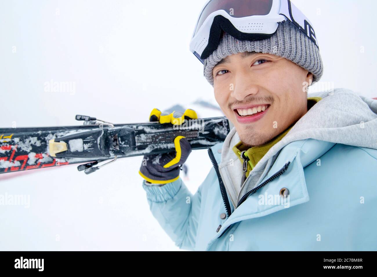 Young man holding skis hi-res stock photography and images - Alamy
