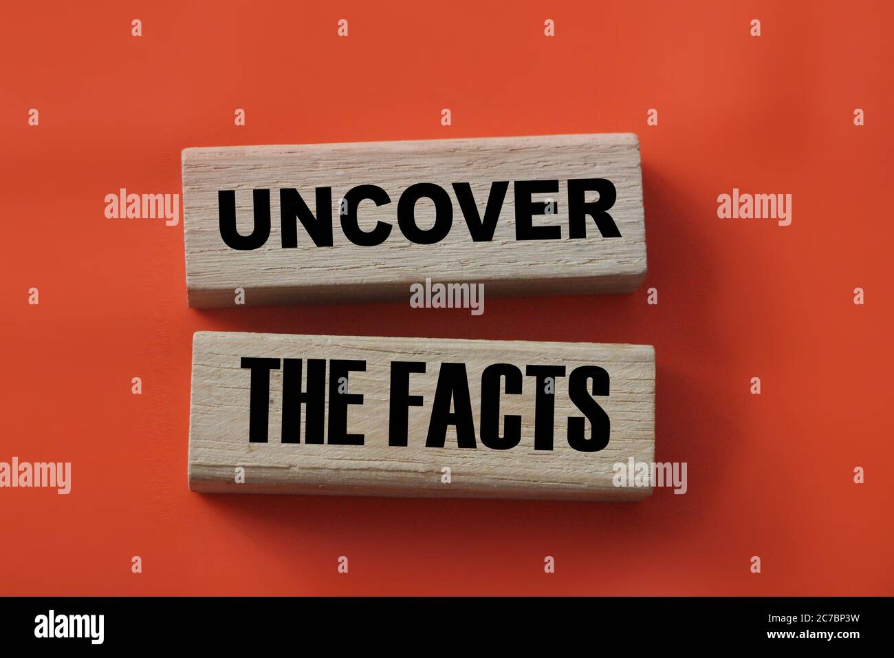 Uncover the facts word wood blocks on red. Fake or real news concept ...