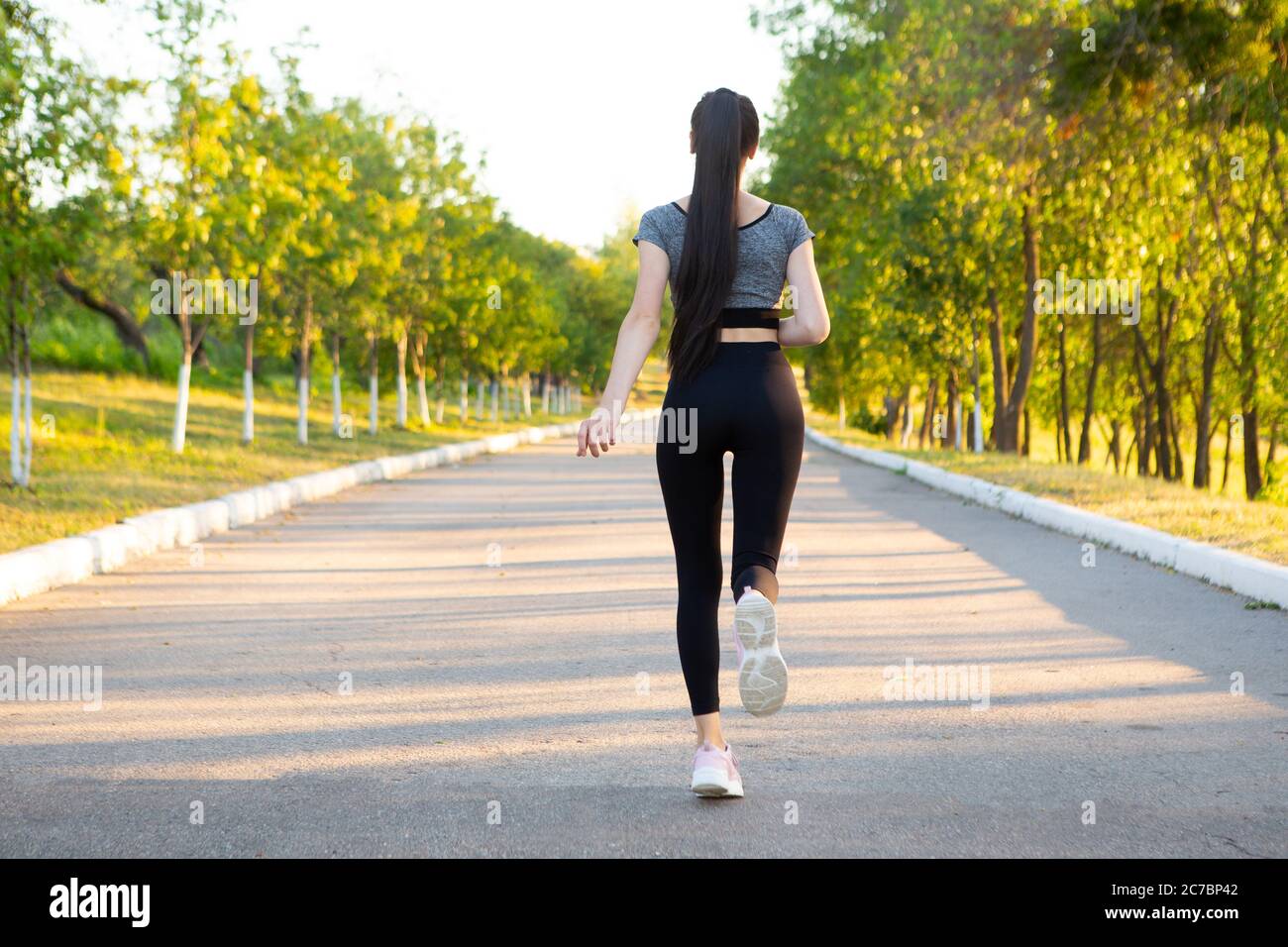 View on back of running woman athlete in the park Stock Photo - Alamy