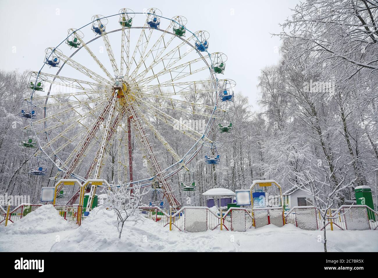 Snow covered Ferris wheel surrounded by snowcovered trees. Lots of snow ...