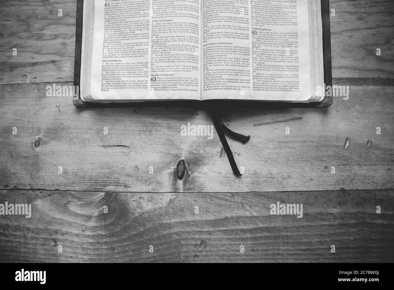 Overhead shot of an open book on a wooden surface in black and white ...