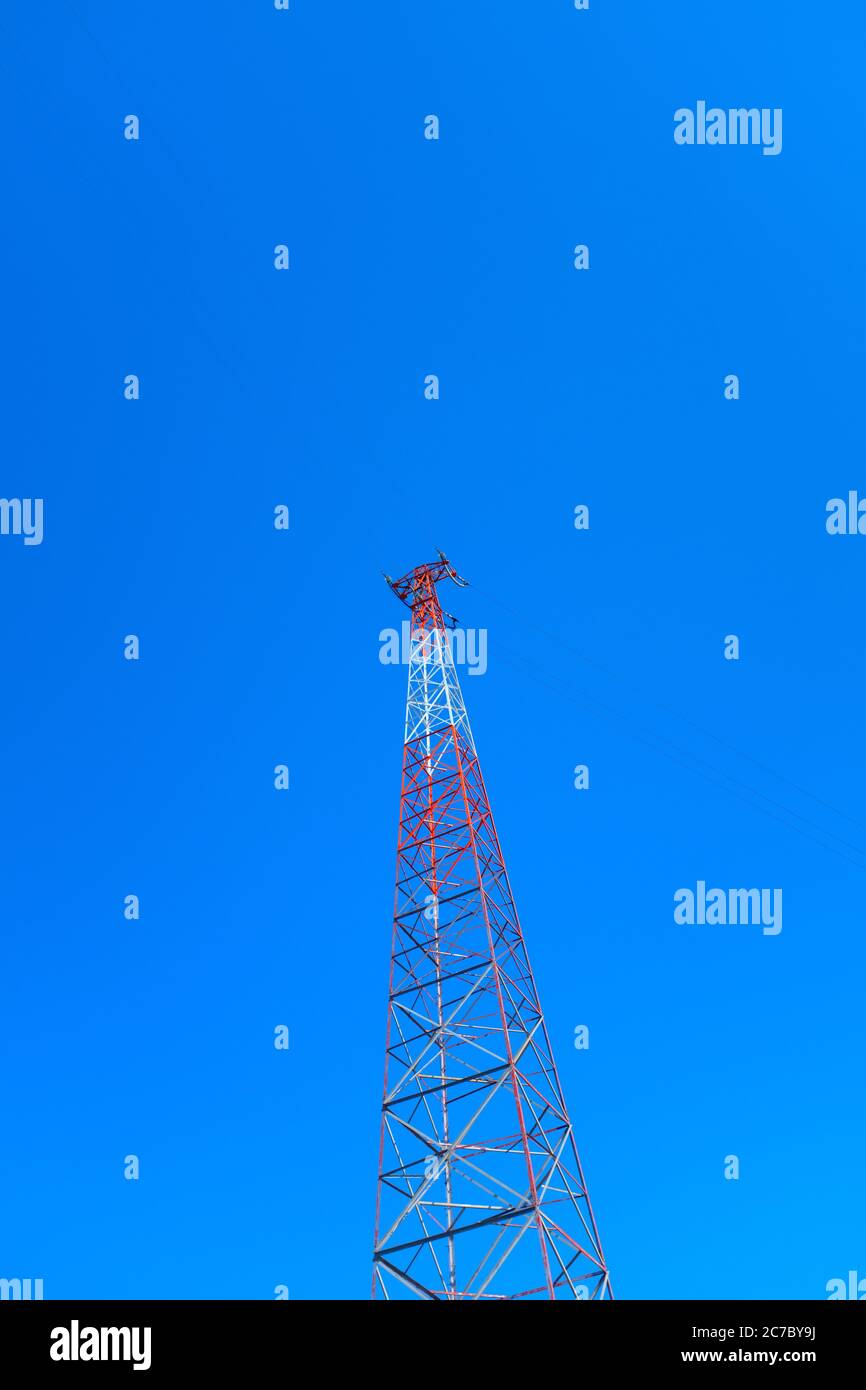 Vertical low angle shot of a tall radio tower under a clear blue ...