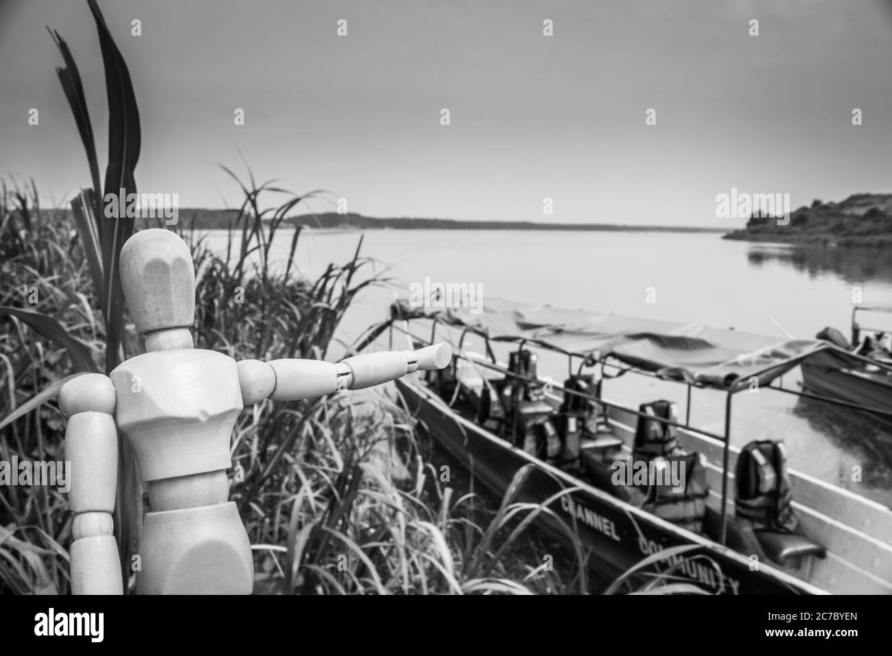 Little wooden manikin pointing to a boat in the Kazinga Channel, Lake ...