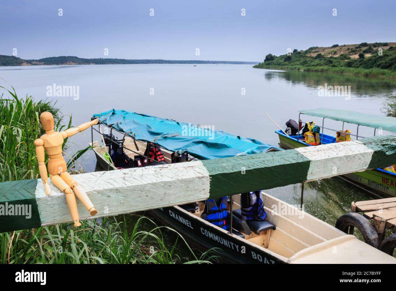 Little wooden manikin pointing to a boat in the Kazinga Channel, Lake ...