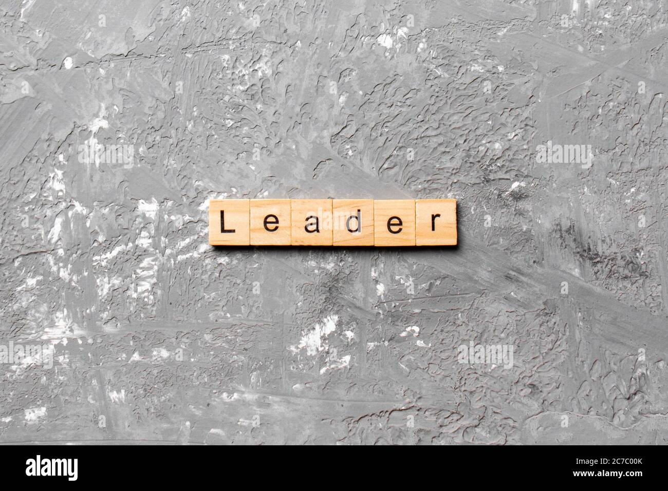leader word written on wood block. leader text on cement table for your ...