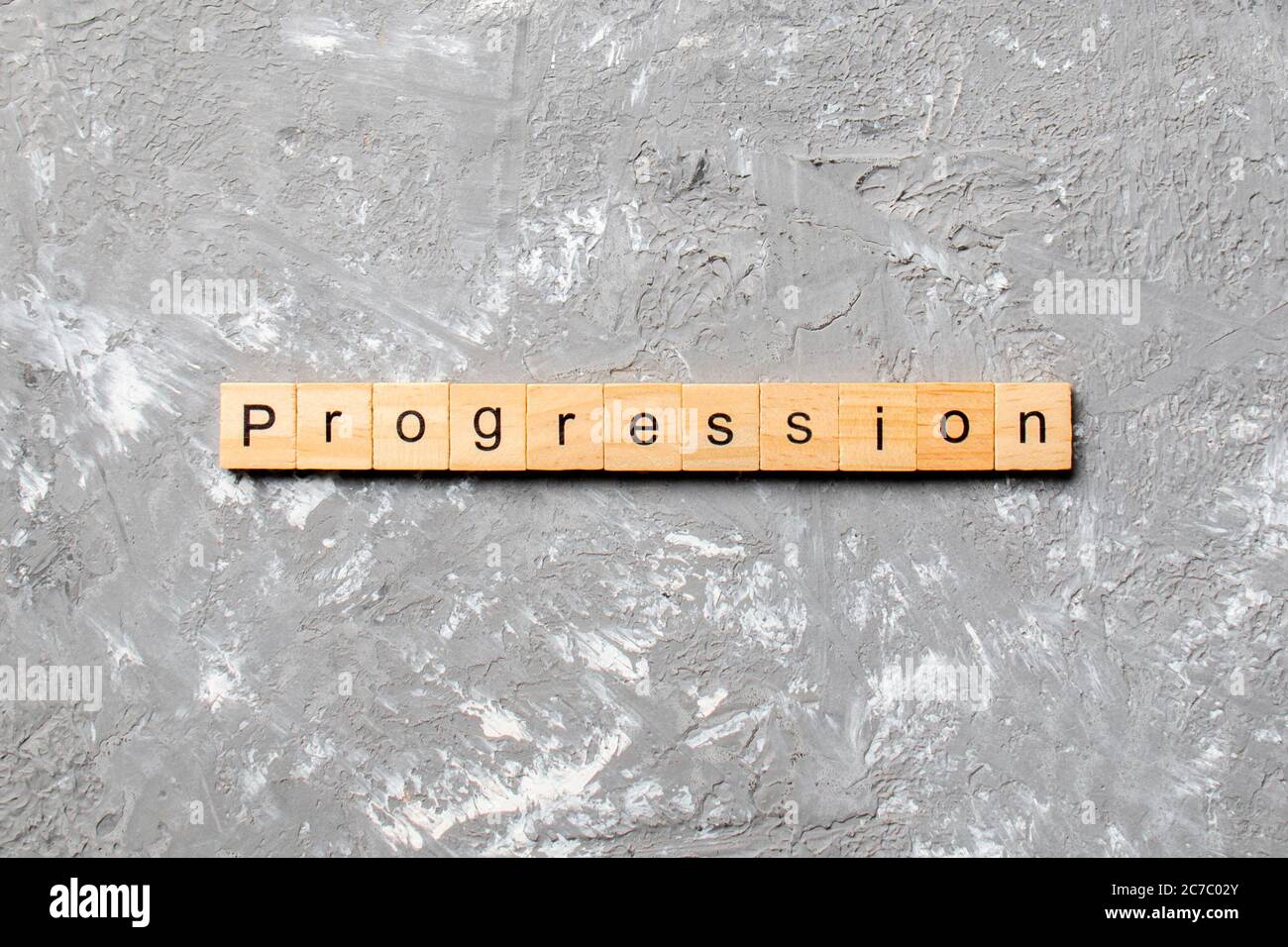 progression word written on wood block. progression text on cement ...