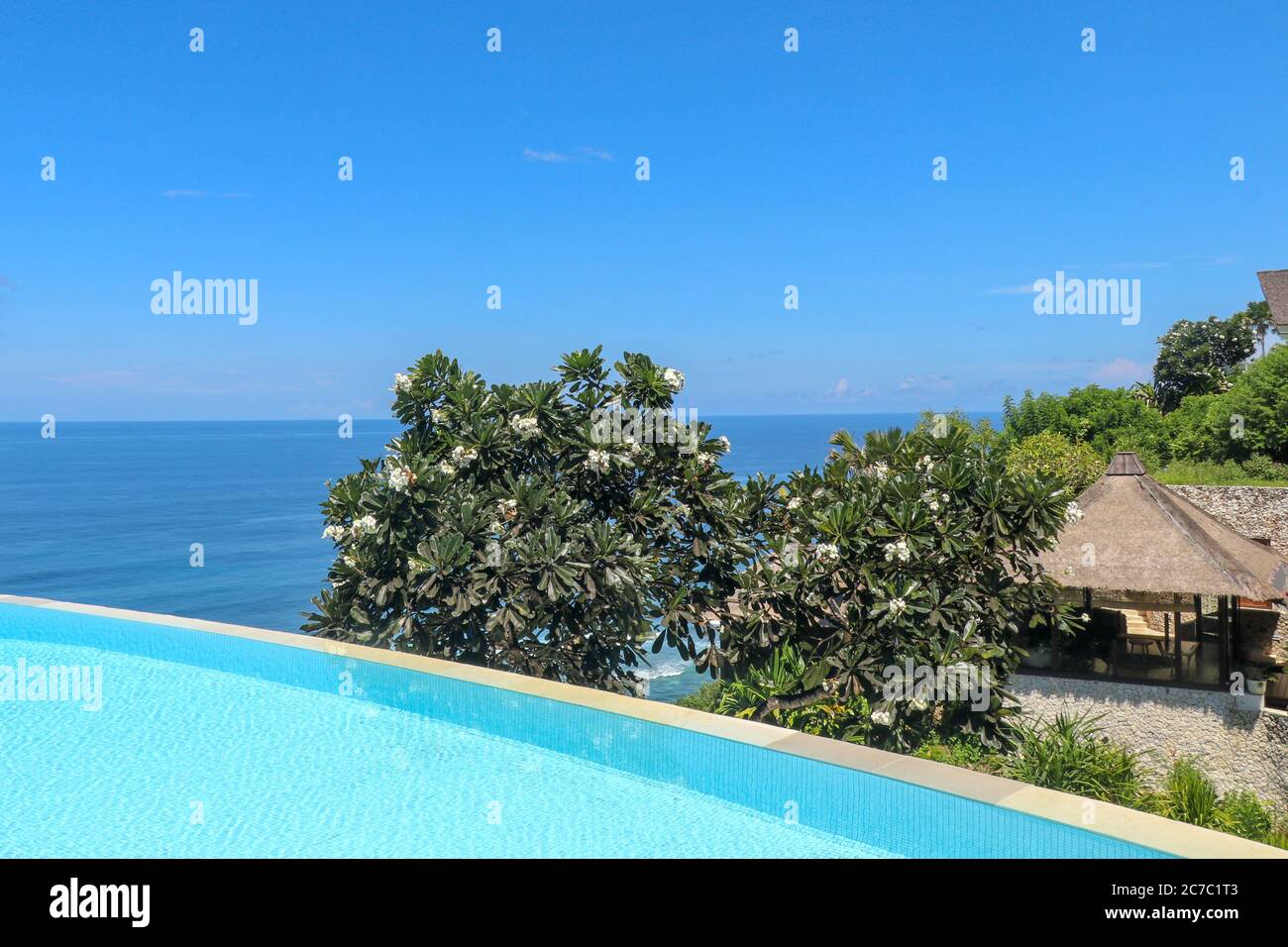 Infinity swimming pool with sea and ocean view on blue sky background ...