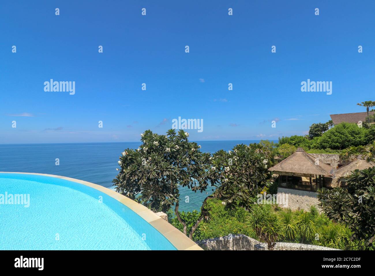 Infinity swimming pool with sea and ocean view on blue sky background ...