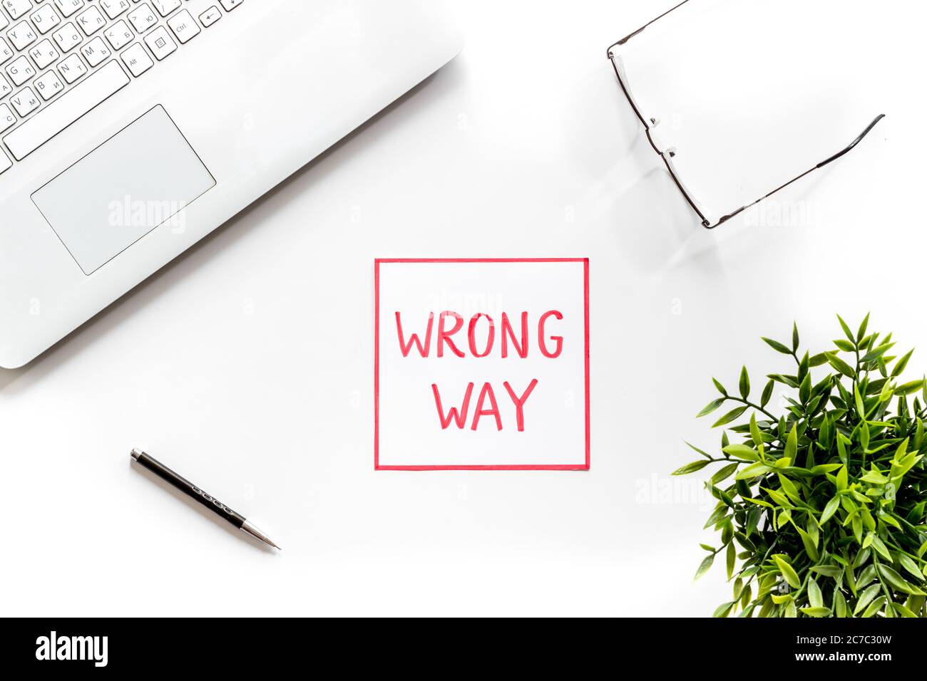 Wrong way icon on office desk - white, top view Stock Photo - Alamy