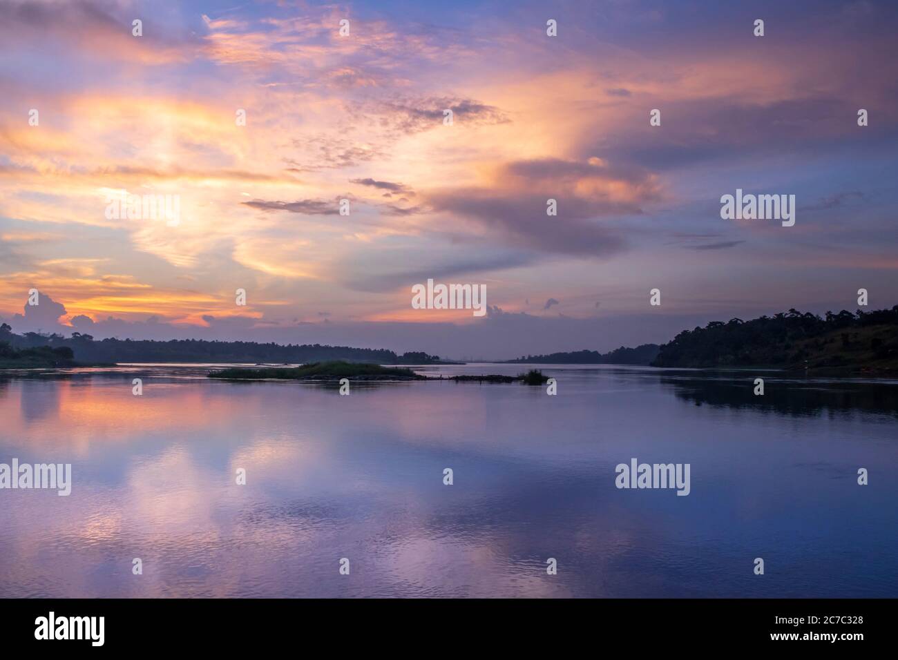 Sunset view of the Victoria Nile river, with trees growing and the ...