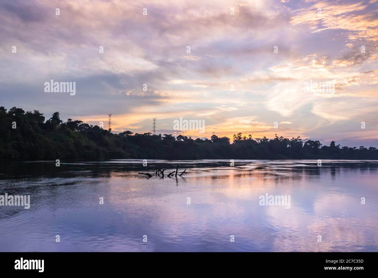 Sunset view of the Victoria Nile river, with trees growing and the ...