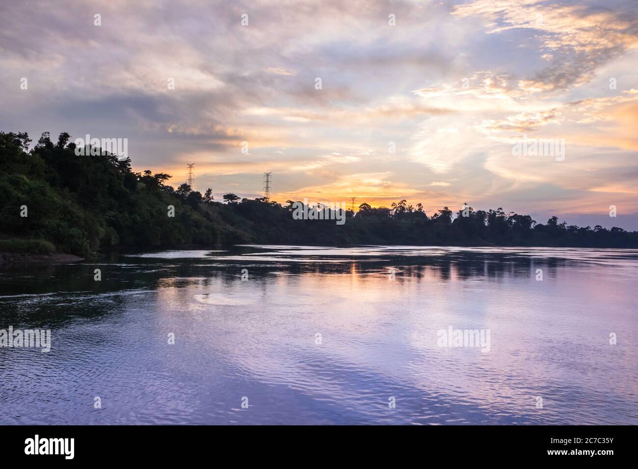 Sunset view of the Victoria Nile river, with trees growing and the ...