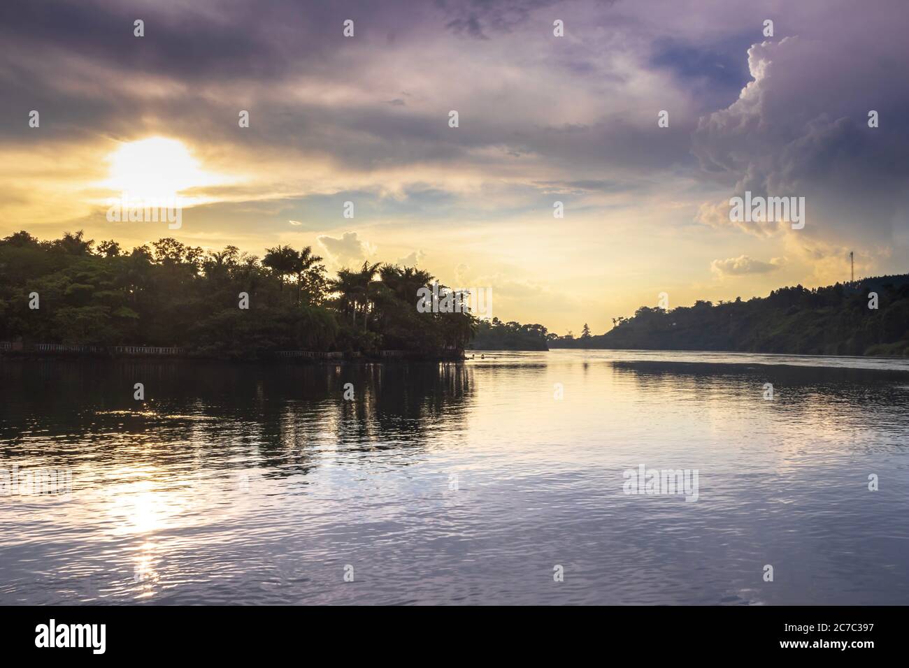 Sunset view of the Victoria Nile river, with trees growing and the ...
