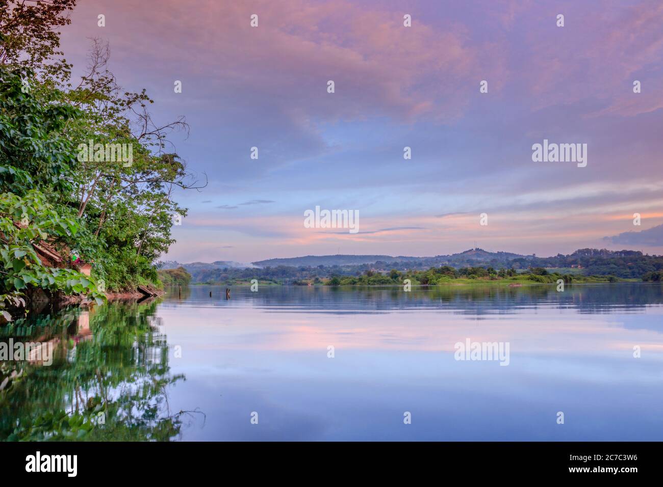 Sunset view of the Victoria Nile river, with trees growing and the ...