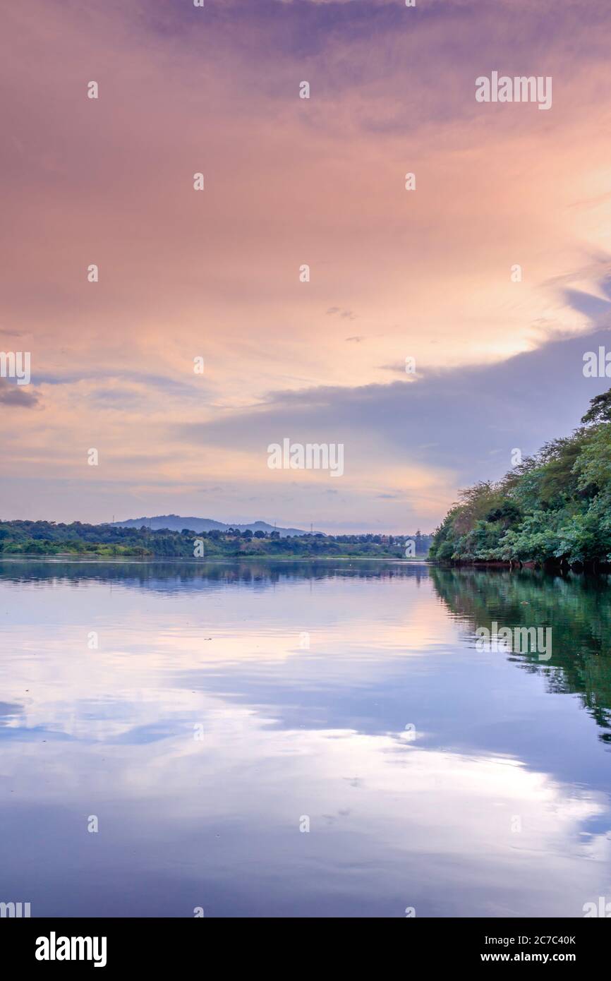 Sunset view of the Victoria Nile river, with trees growing and the ...