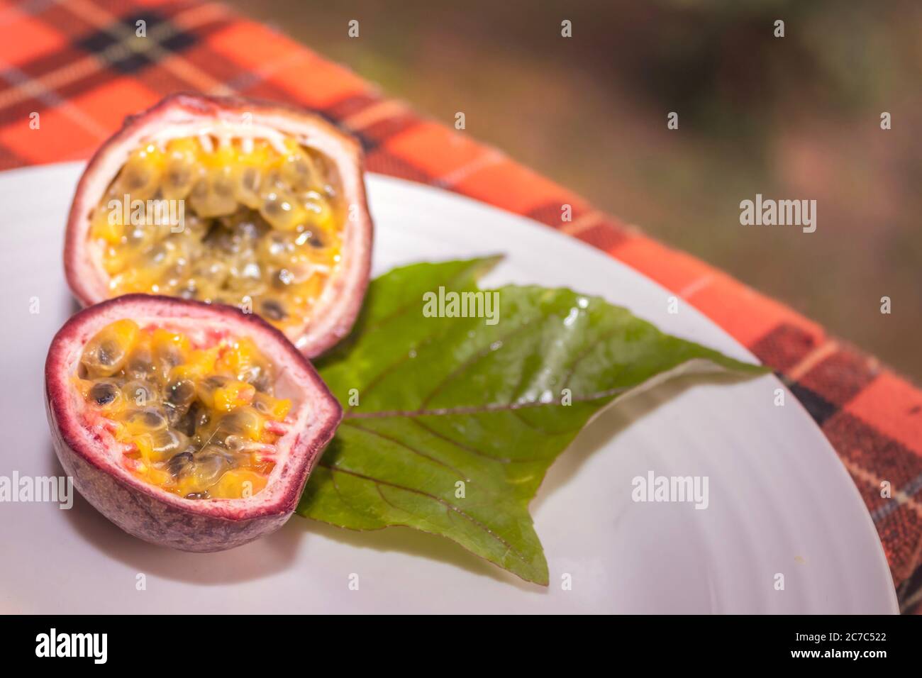 Passion fruit (Passiflora edulis) fruit on a white table plate, Uganda ...