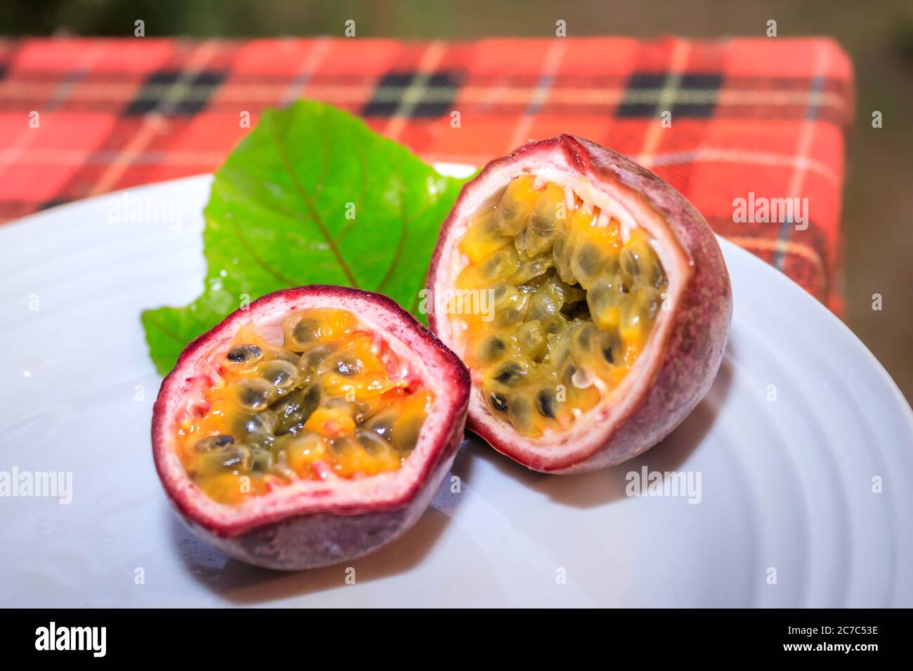 Passion fruit (Passiflora edulis) fruit on a white table plate, Uganda ...