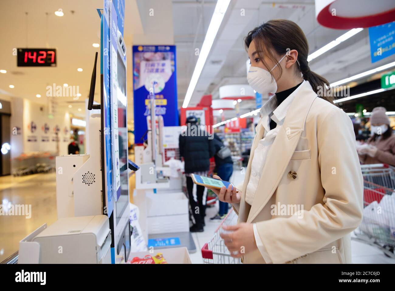 Wearing a mask of young women shopping in the supermarket Stock Photo ...