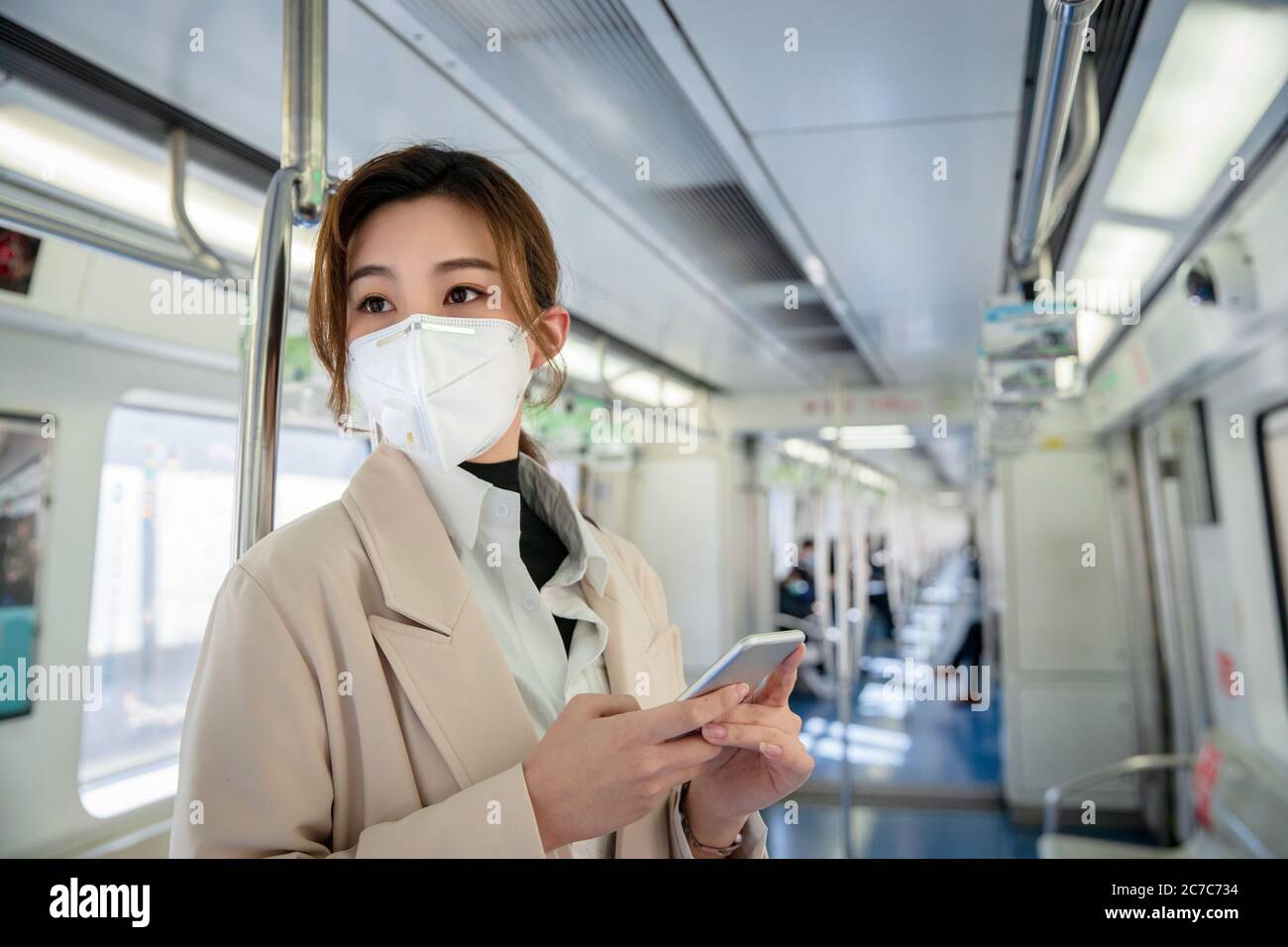 Wearing a mask of the young woman standing in the subway Stock Photo ...