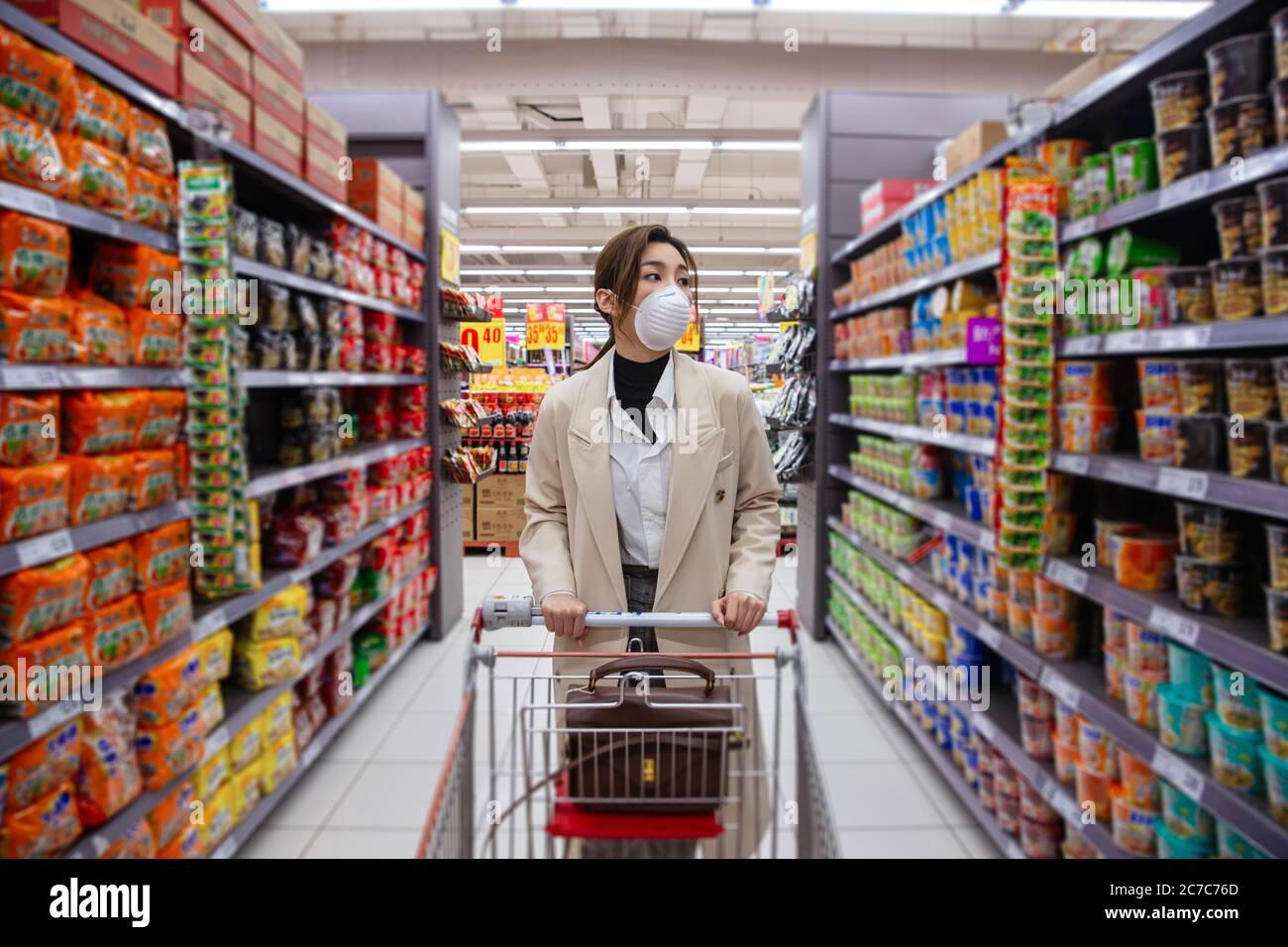 Wearing a mask of young women shopping in the supermarket Stock Photo ...