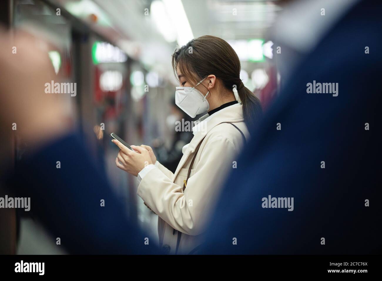Wearing a mask of the young woman stood on the subway platform Stock ...