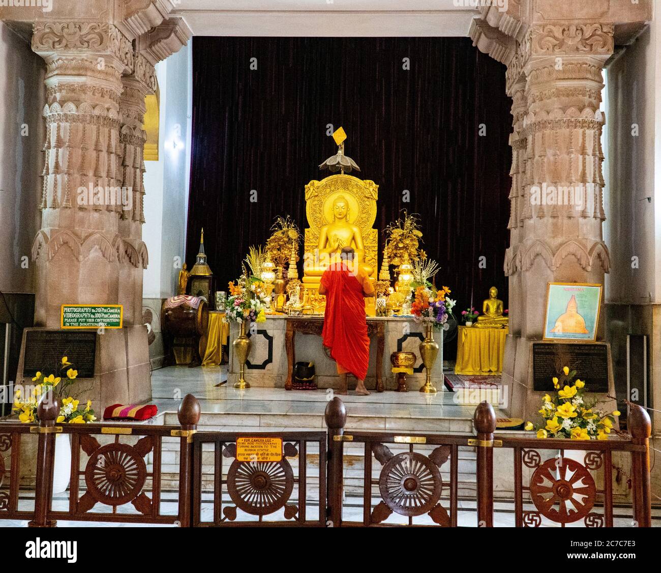 Wide shot of golden Buddha statue in altar inside of the Mulagandha ...