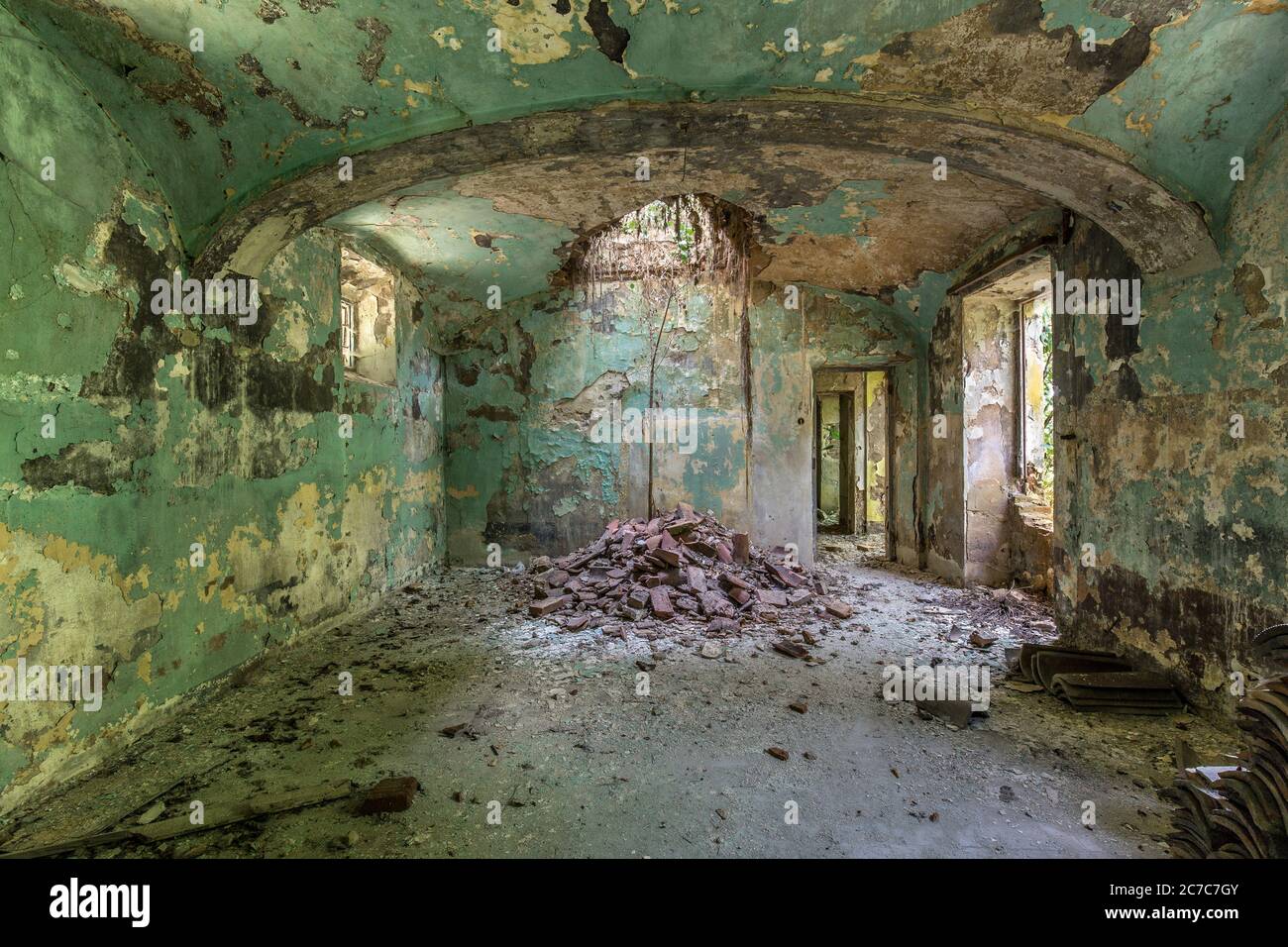 Interior shot of an abandoned building interior with green walls and ...