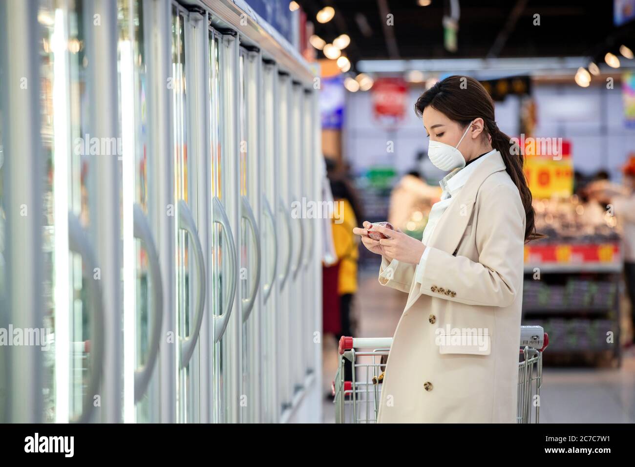 Wearing a mask of young women shopping in the supermarket Stock Photo ...
