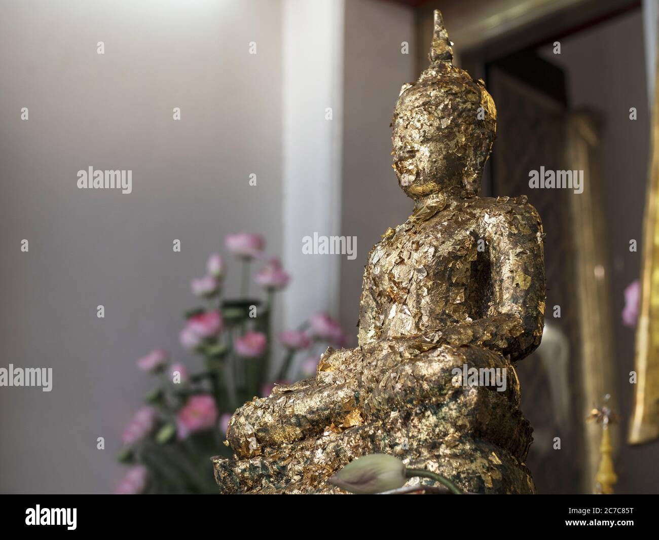 Closeup shot of a golden, worn-out buddha statue in a temple Stock ...
