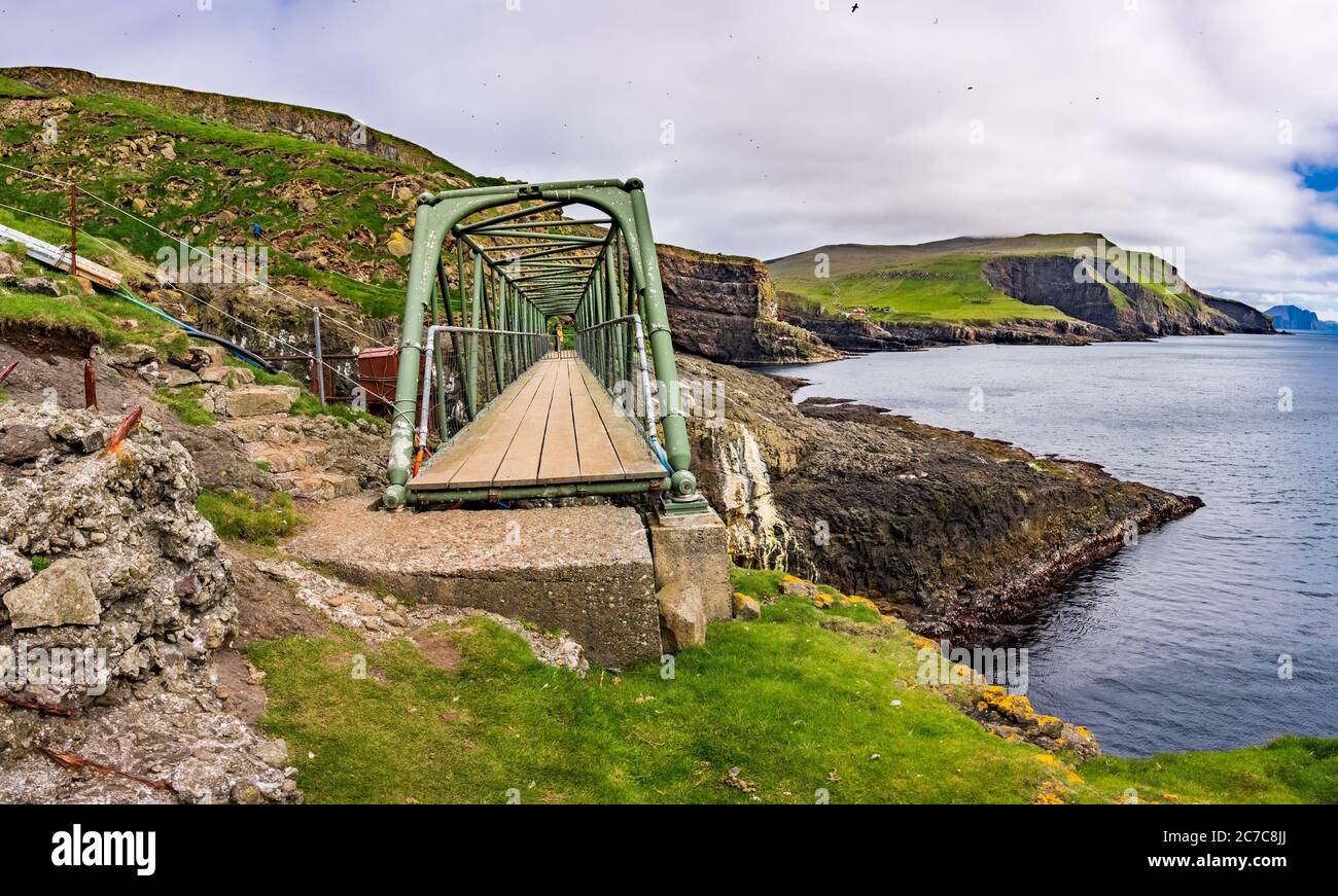 Suspension bridge in Mykines island connecting islands Stock Photo - Alamy