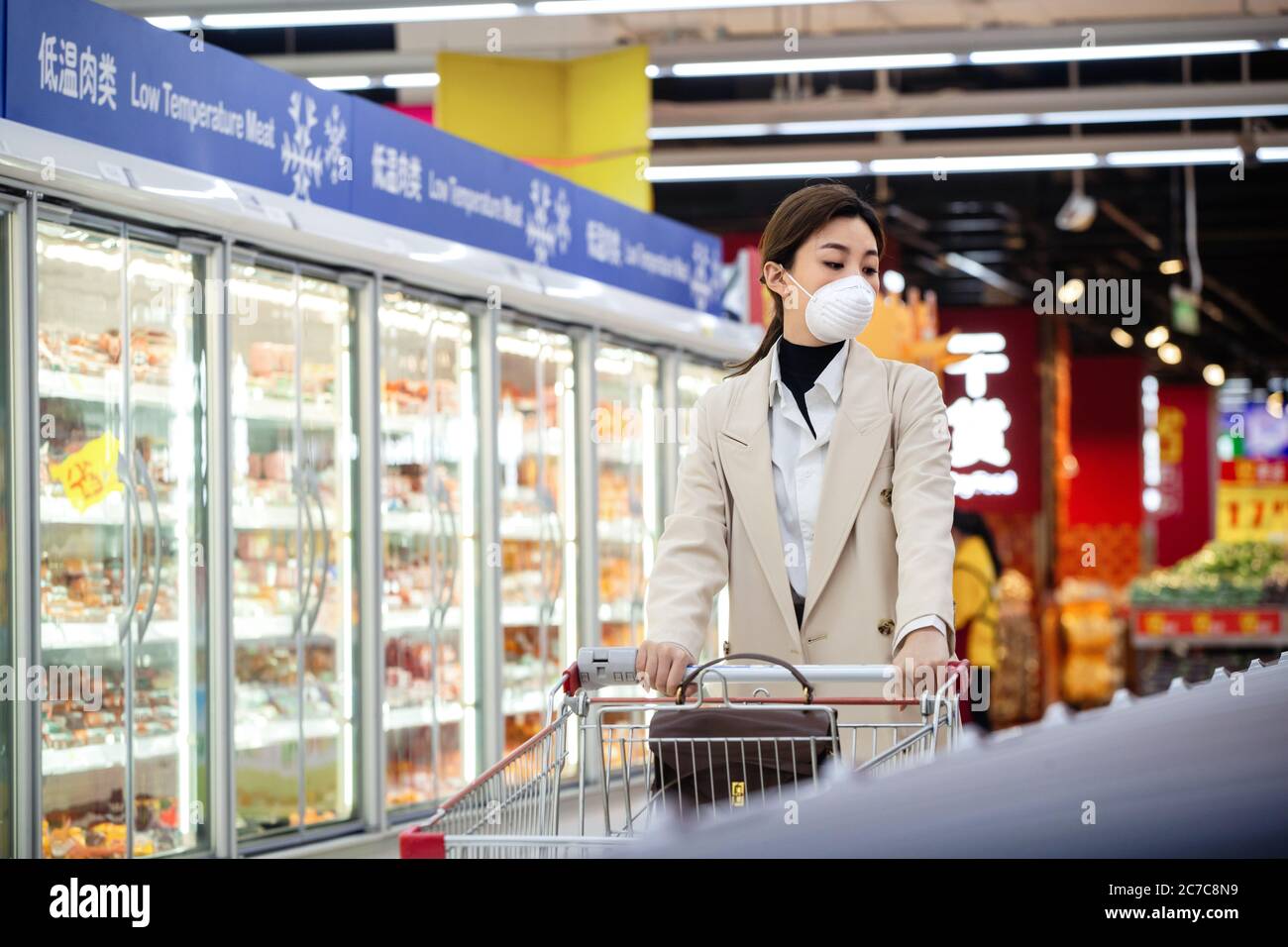 Wearing a mask of young women shopping in the supermarket Stock Photo ...