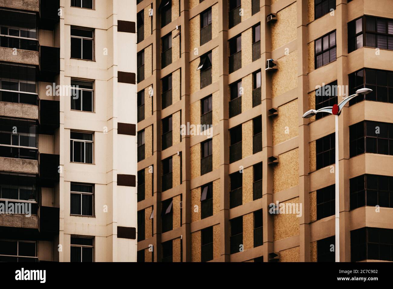 Horizontal shot of tall buildings in a city with a lamppost visible ...