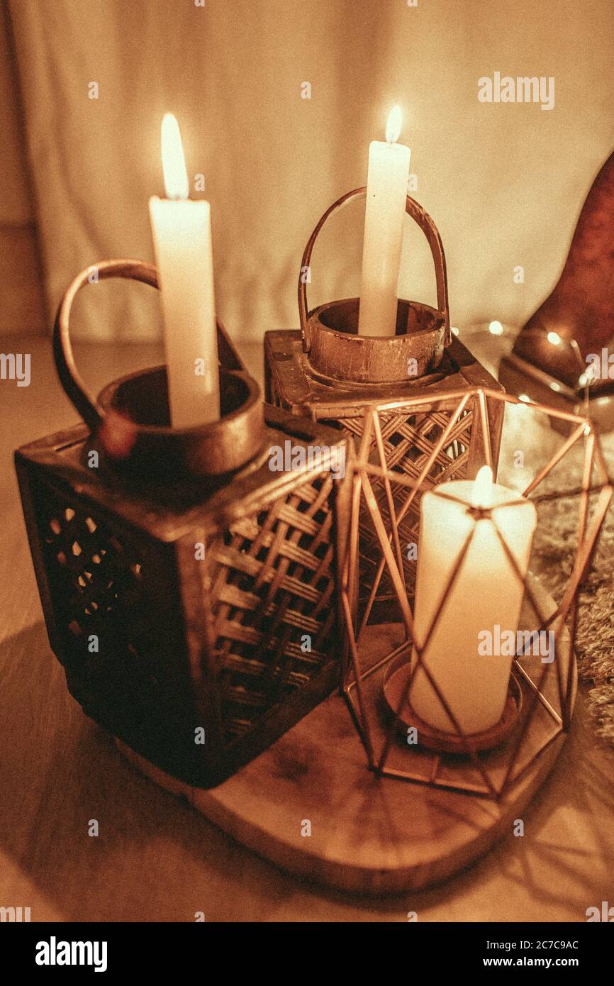 Vertical shot of three lit white taper candles on a table Stock Photo ...