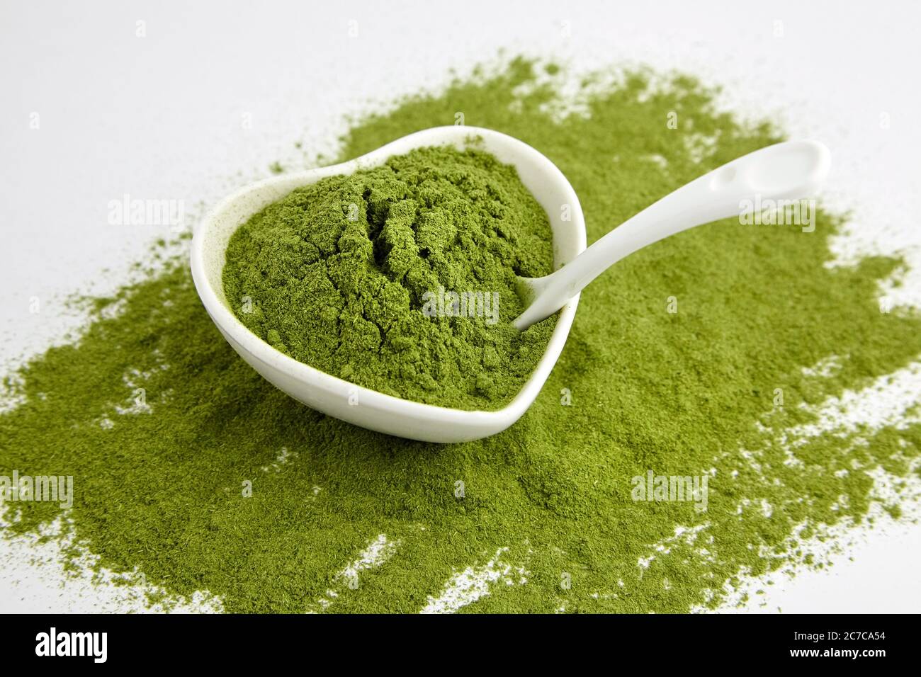 Green freeze dried wheat or barley grass powder in ceramic bowl with ...