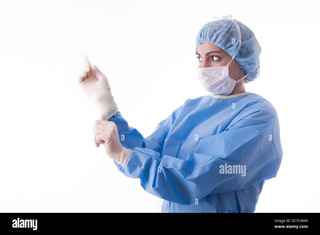 Female surgeon or nurse wearing a sterile blue suit putting on sterile ...