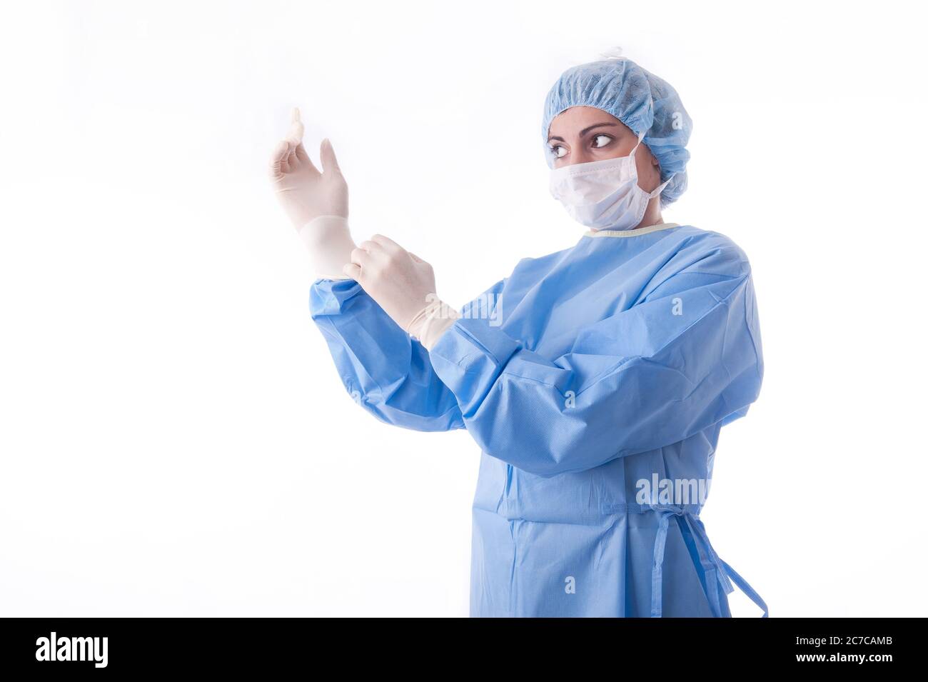 Female surgeon or nurse wearing a sterile blue suit putting on sterile ...