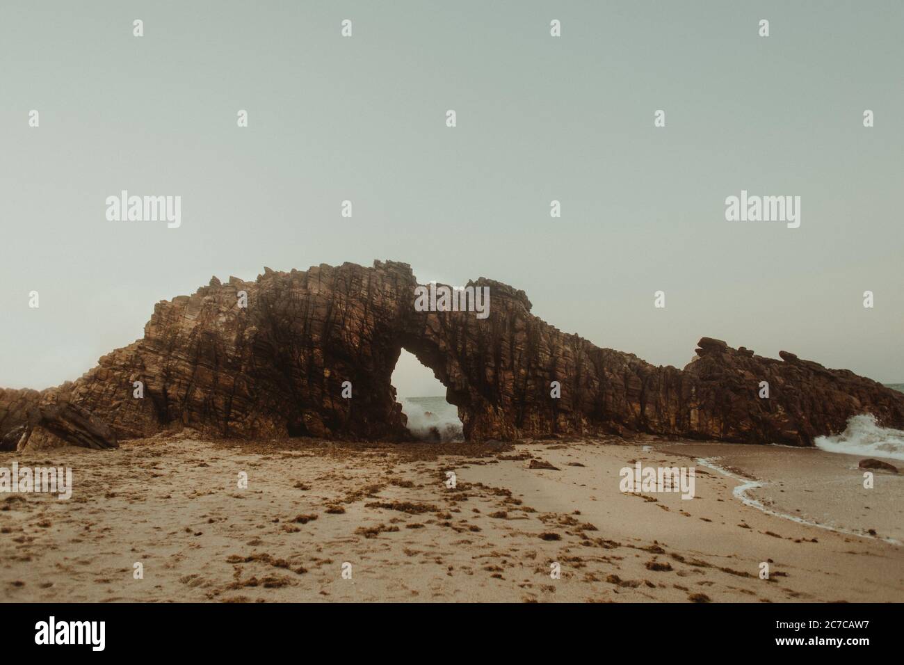 Landscape shot of a cliff with an arc on a sandy beach Stock Photo - Alamy