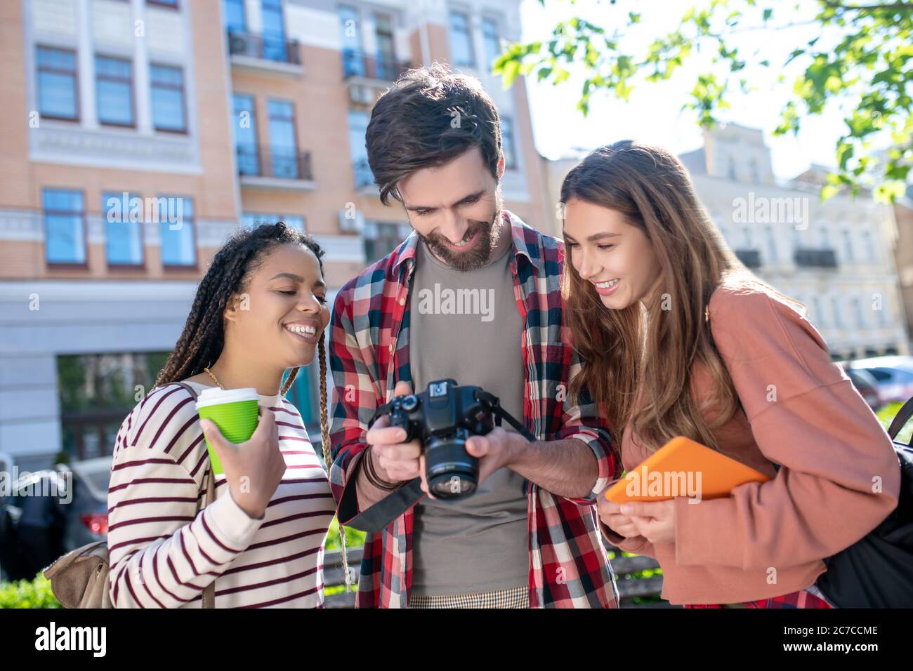 Guy with a camera showing girls pictures Stock Photo - Alamy