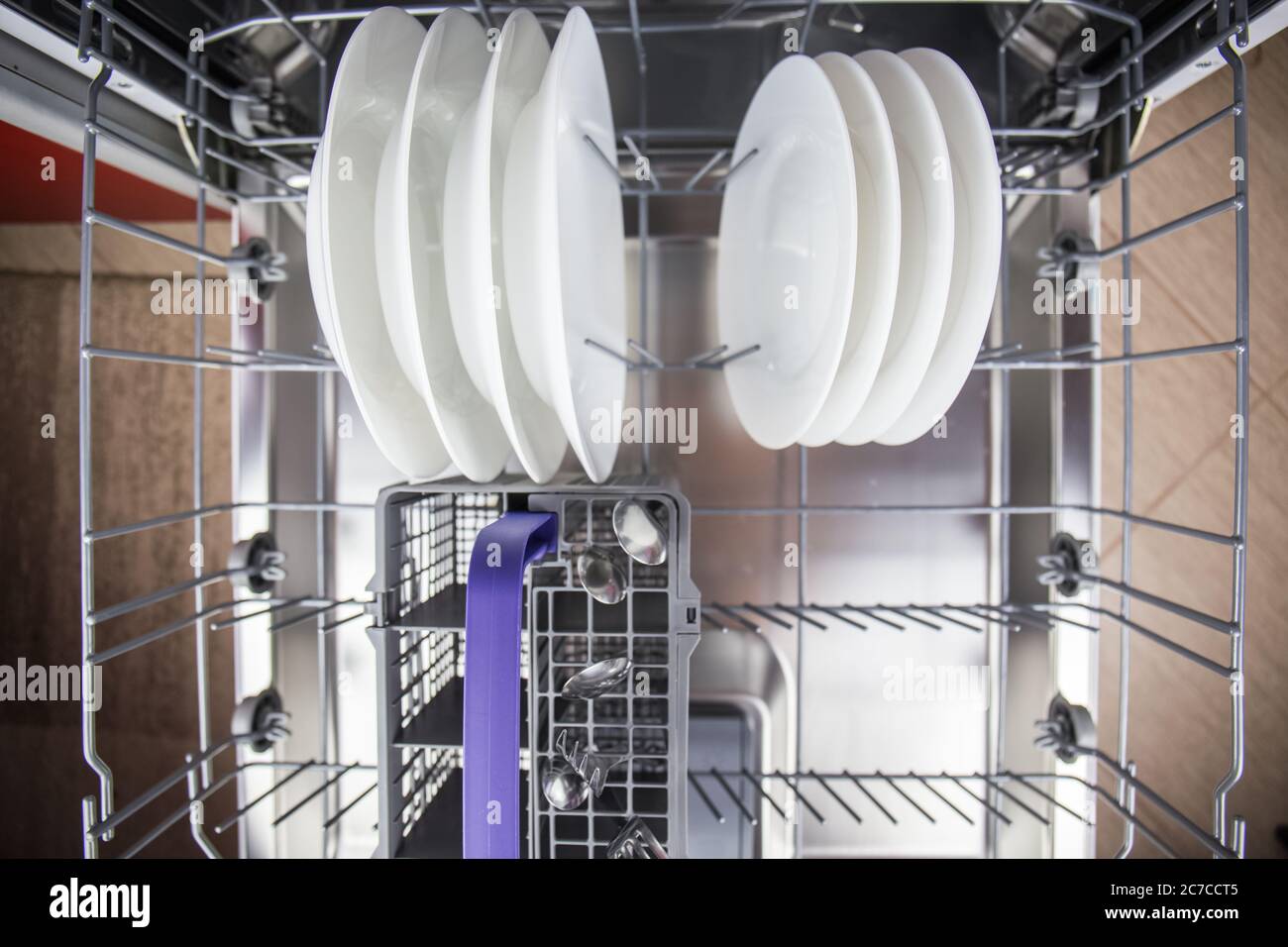 Stacked plates in dishwasher to be cleansed of stains with hot water ...