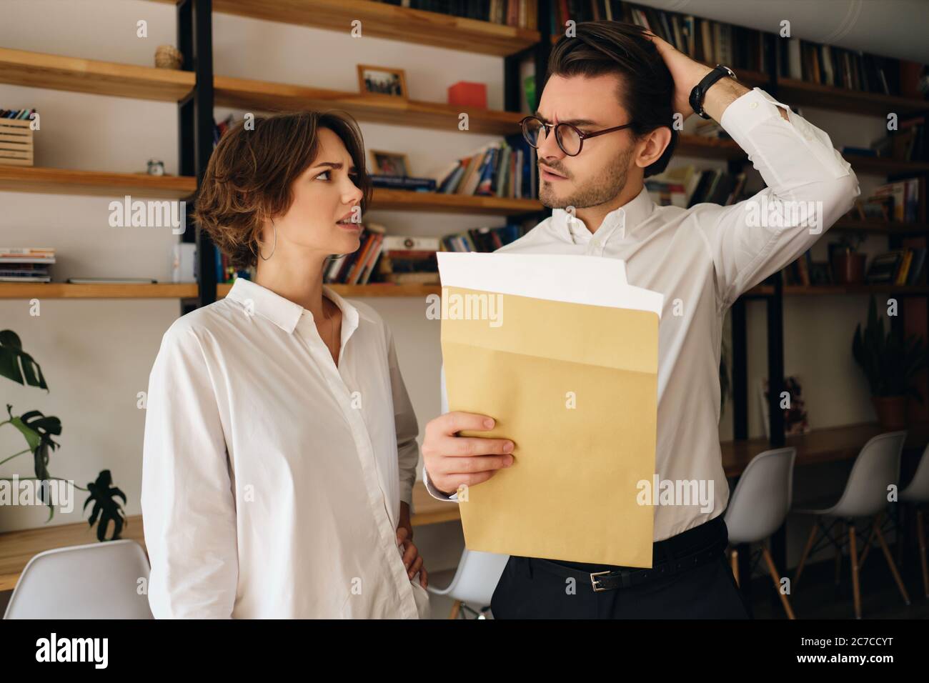 Young disappointed business colleagues standing with envelope letter ...