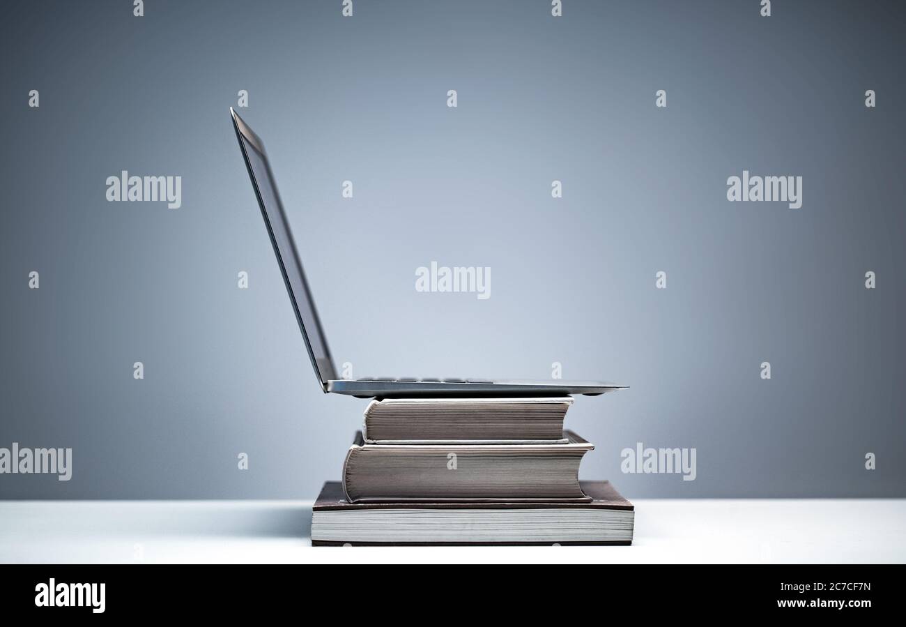 Stack of books and notebook computers together Stock Photo - Alamy