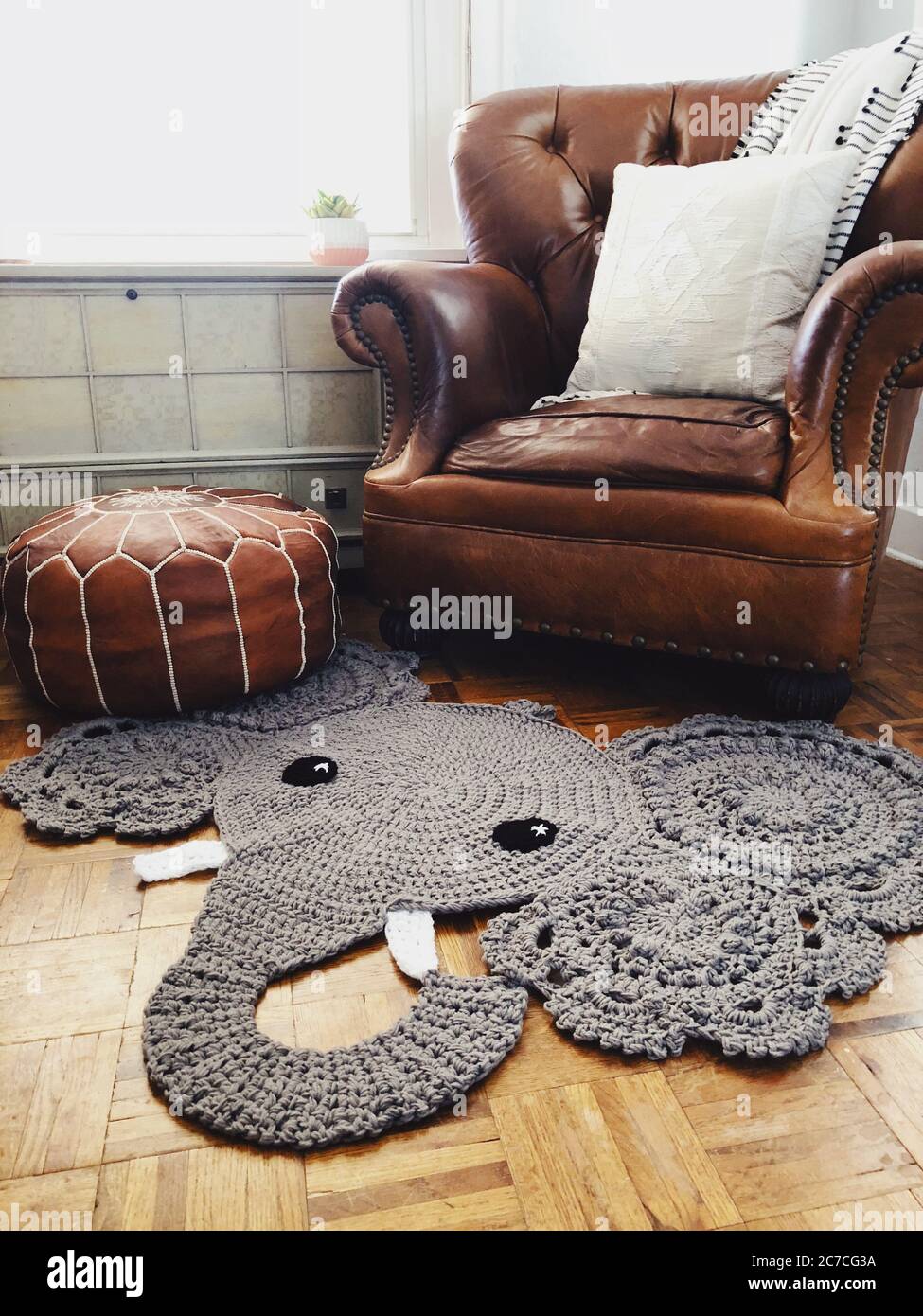 High angle shot of a cute crochet elephant carpet on the ground near ...