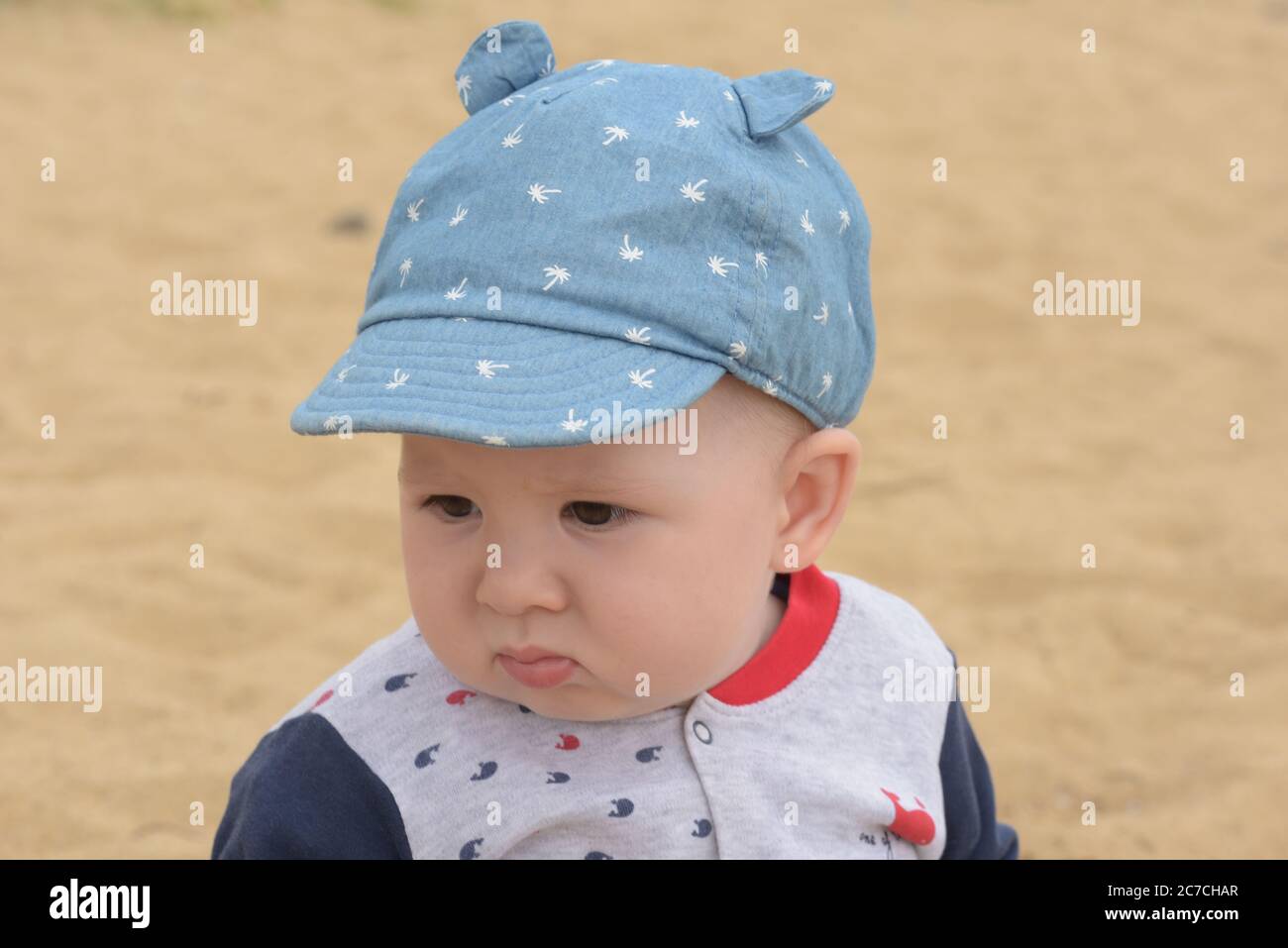 Toddler boy sitting on the sand Stock Photo - Alamy